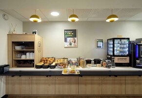 Um buffet de café da manhã com diversos alimentos e uma máquina de café.