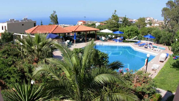 Uma área de piscina com um gazebo, espreguiçadeiras e guarda-sóis.