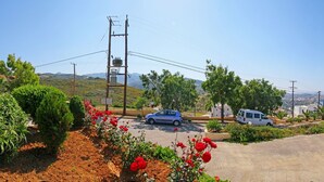 Um terreno em encosta com um caminho de pedra que leva a um edifício com varanda.
