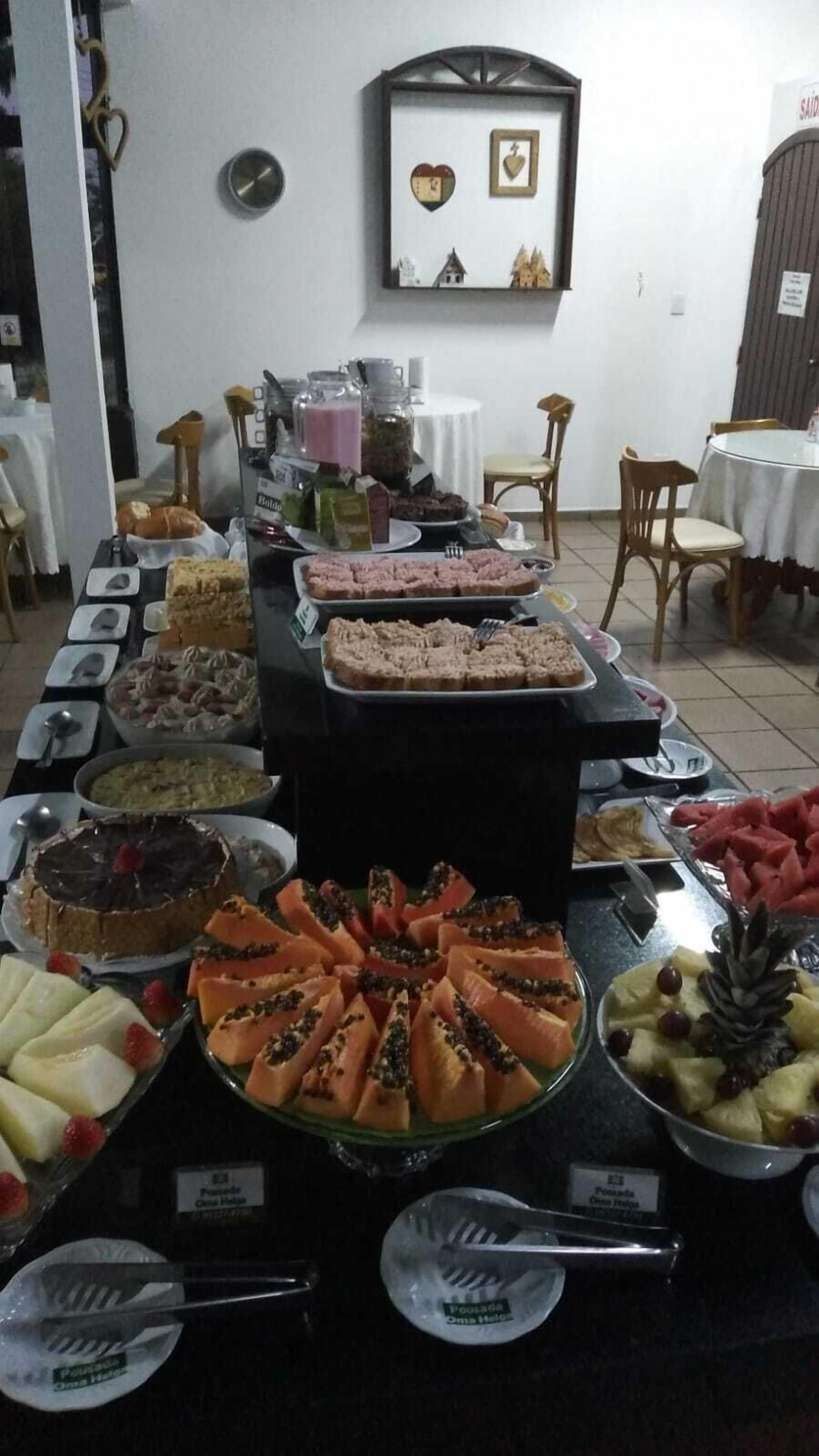 Uma mesa de buffet com diversos alimentos e um relógio na parede.