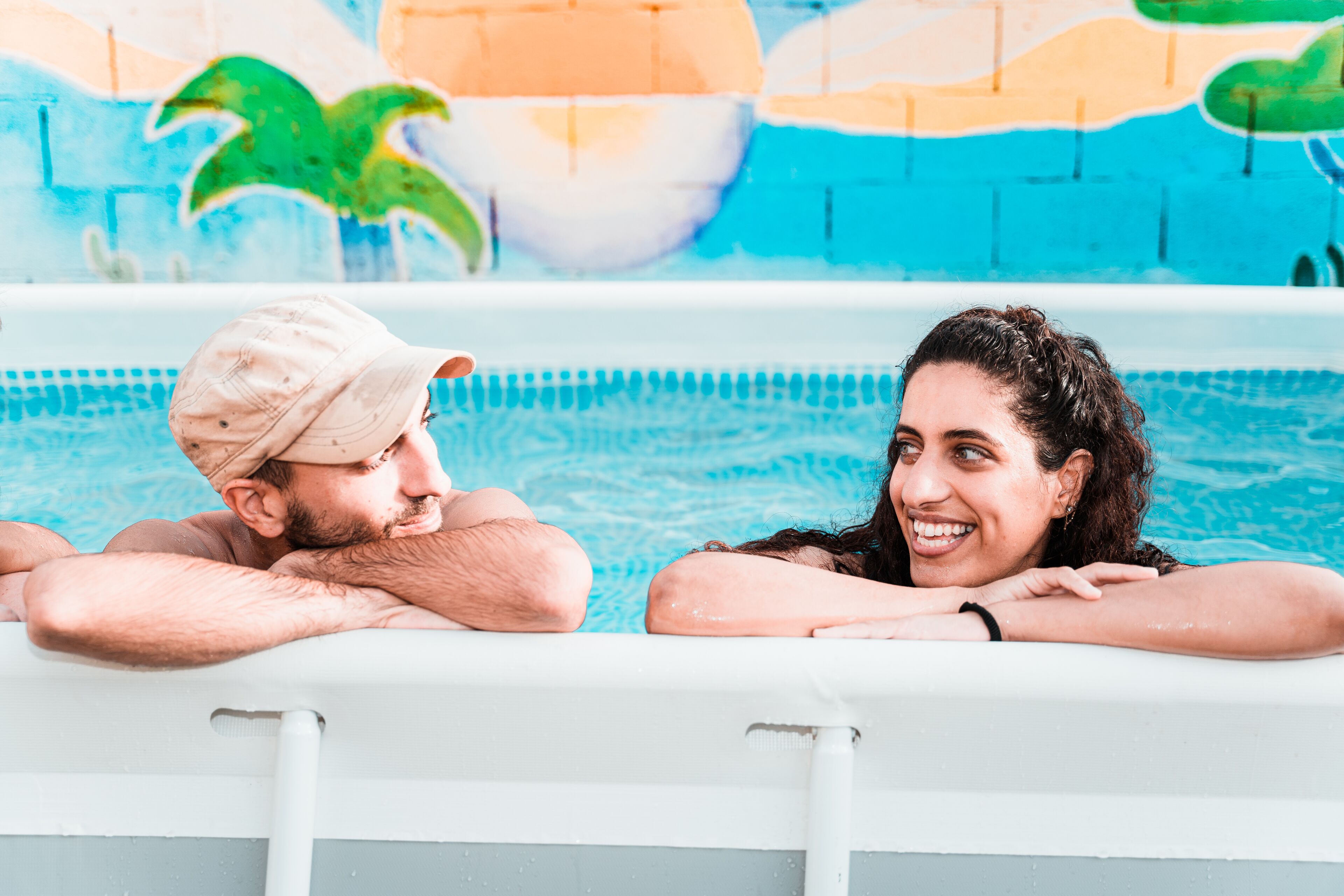 Piscina com um mural na parede.