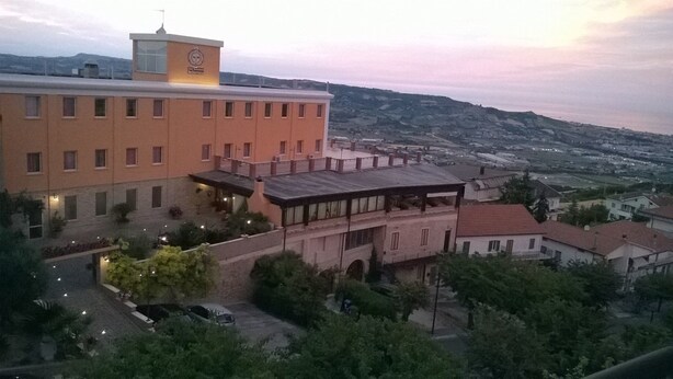 Um hotel com um pátio central, vários edifícios e vista para a paisagem ao redor.