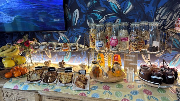 Um buffet de café da manhã com diversos alimentos e acompanhamentos.
