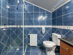 Chuveiro, toalhas de banho, sabonete, papel higiênico