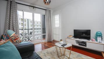 Apartamento, 1 quarto, varanda, vista parcial para o mar | Sala | TV de ecrã plano