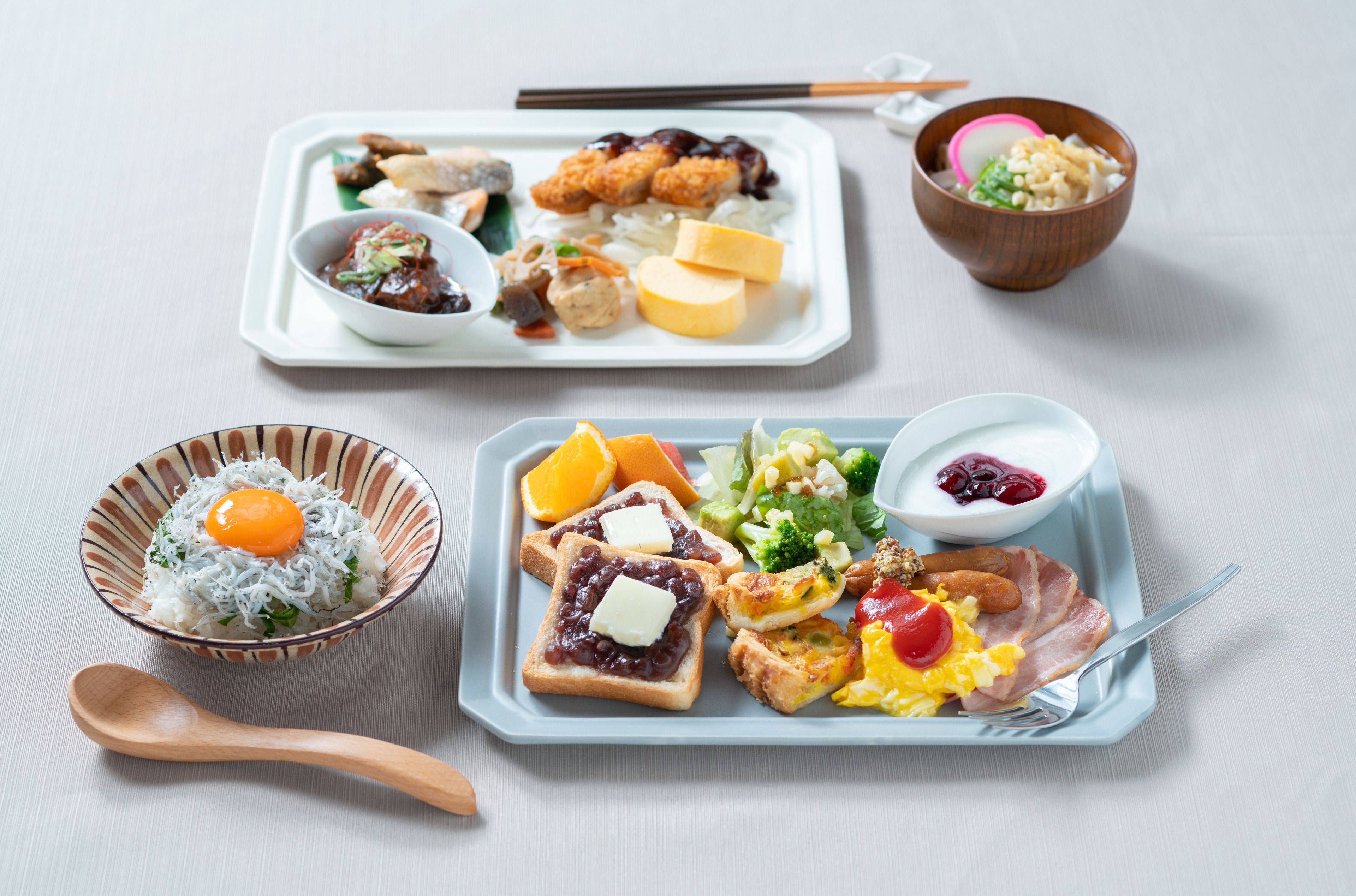 Diversos pratos em duas travessas, incluindo sushi, sashimi e uma salada.