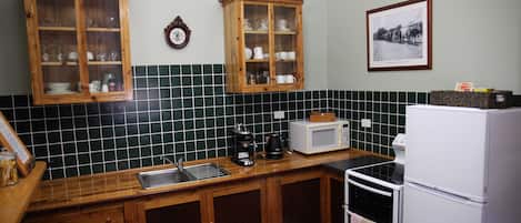 Apartamento superior, 1 cama Queen, terraço | Cozinha privada | Geladeira grande, micro-ondas, fogão, cooktop