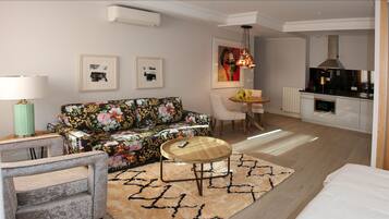 Uma sala de estar moderna com um sofá, uma mesa de centro redonda, um abajur e um tapete.