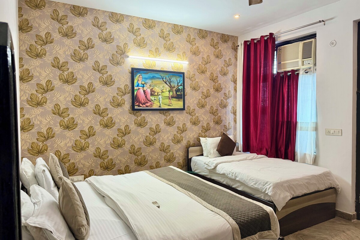 Quarto de hotel com duas camas, um quadro na parede e janela com cortinas.