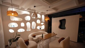 Um interior moderno com designs de parede únicos, uma mesa de madeira e assentos confortáveis.
