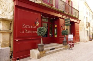 Um edifício vermelho com uma placa que diz 'Restaurant La Parenthese'.