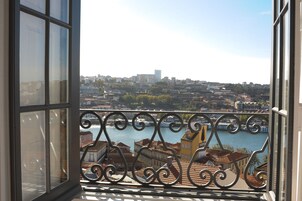 Uma varanda com vista para um rio e o horizonte urbano.