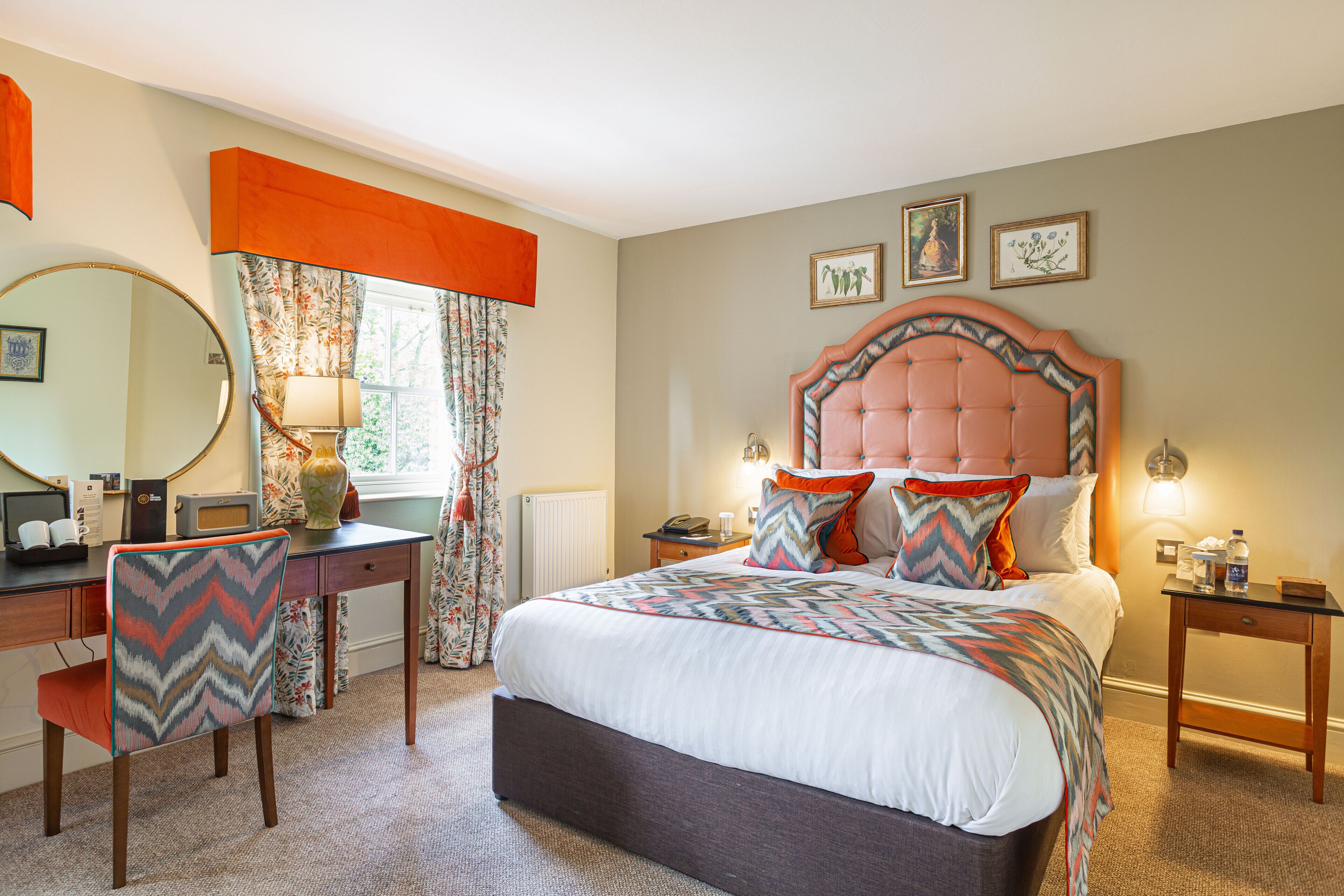 Quarto com cama, escrivaninha, cadeira, espelho e mesa de cabeceira.