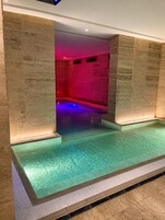 Uma área de spa com hidromassagem e piscina separada.