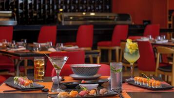 Um sushi bar com diversos pratos e bebidas.