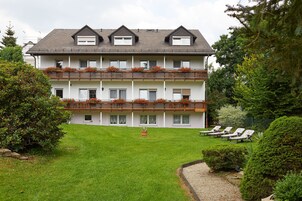 Um hotel de vários andares com um jardim bem cuidado, área de estar externa e um jardim.