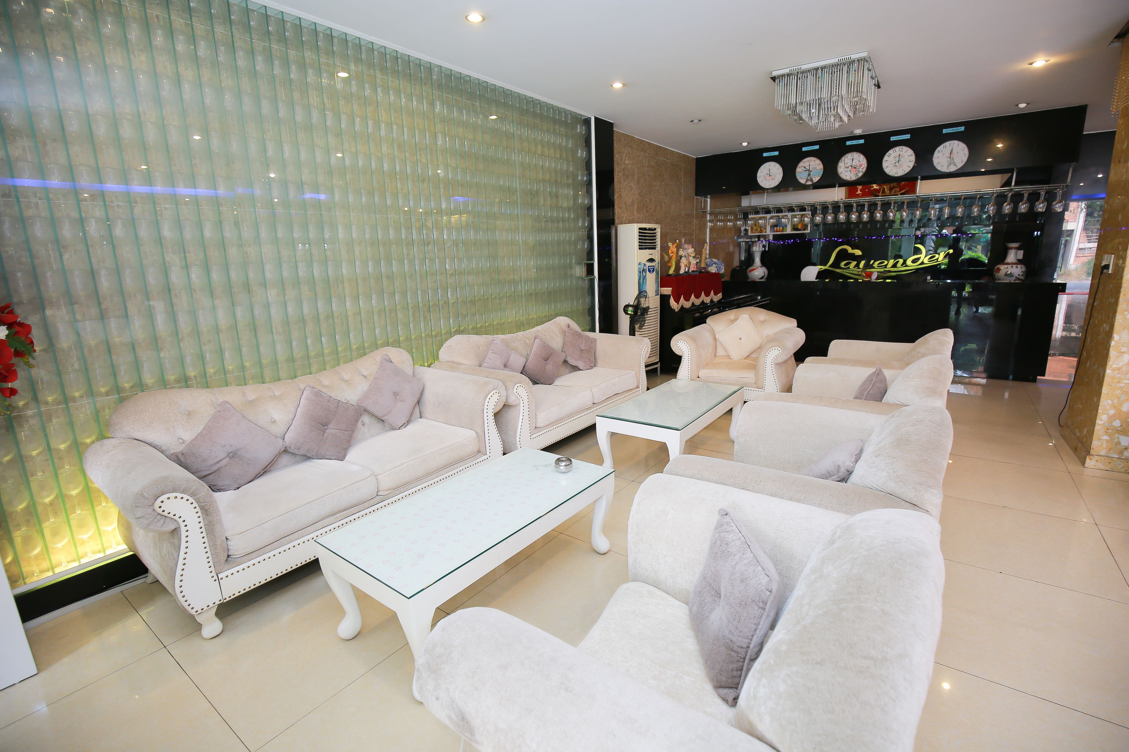 Uma sala de estar moderna com um sofá, uma mesa de centro e um espaço bar ao fundo.