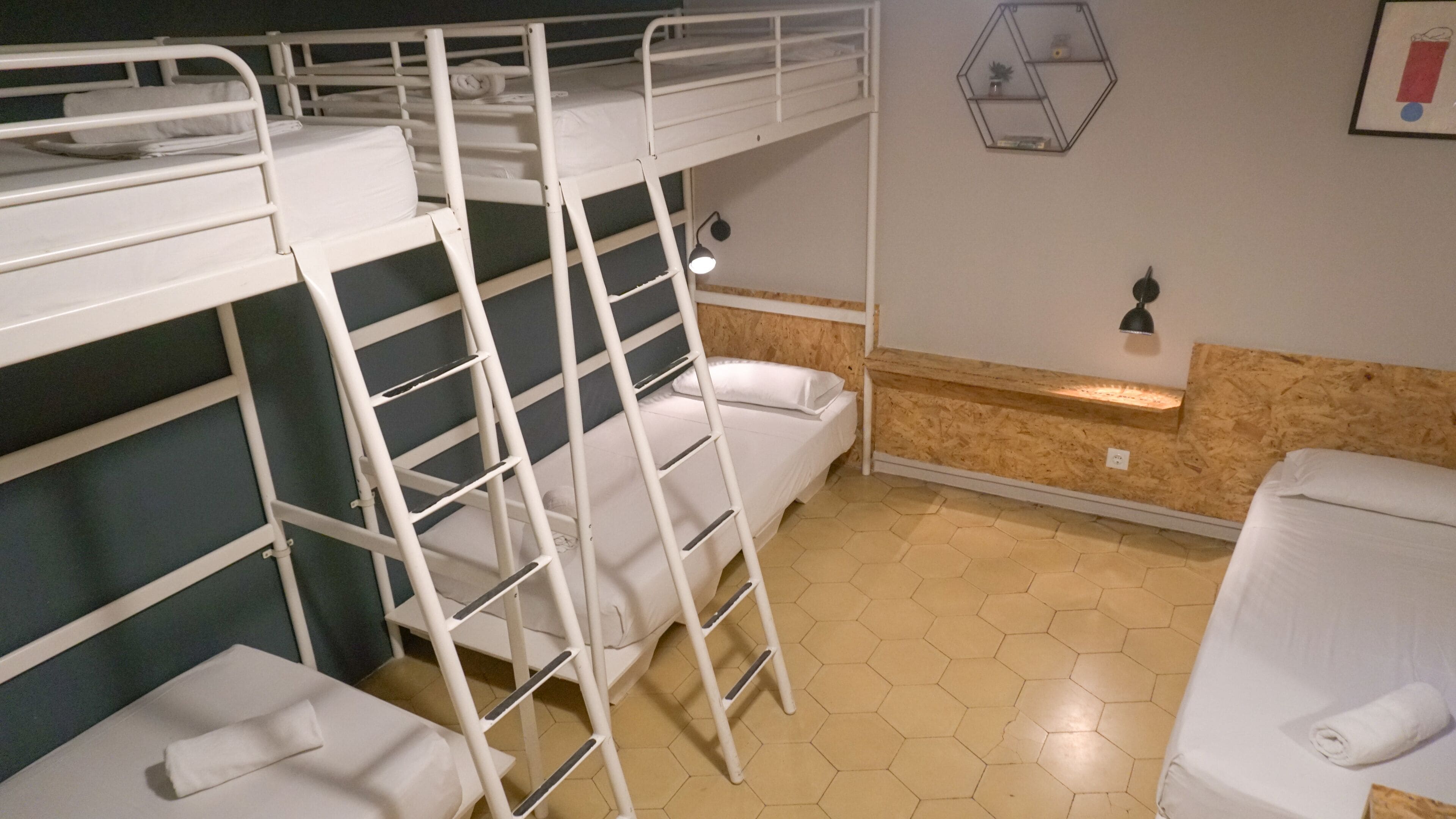 Quarto com beliche, uma pequena estante e uma casa de banho.