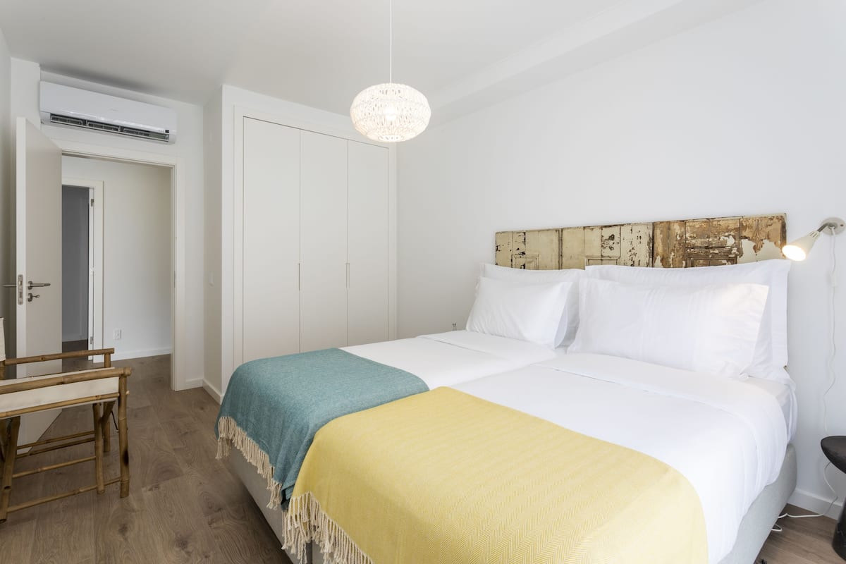 Quarto com cama, mesa de cabeceira e guarda-roupa.