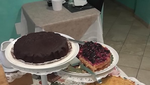 Uma mesa com três bolos e uma seleção de fatias de pão.