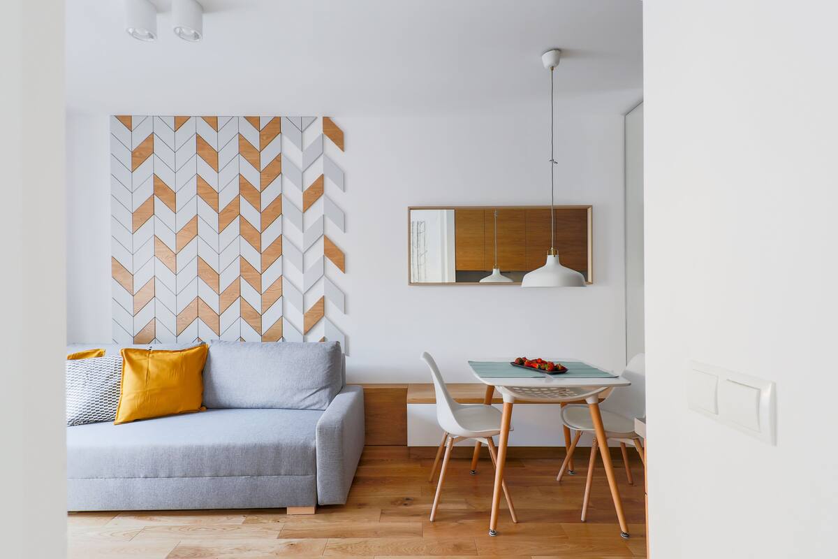 Uma sala de estar moderna com sofá, mesa de jantar e cadeiras.