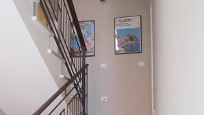 Uma escadaria com degraus de mármore e corrimão de metal.