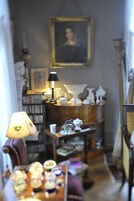 Uma sala de estar aconchegante com uma mesa de centro de madeira, uma luminária, estante e objetos decorativos.