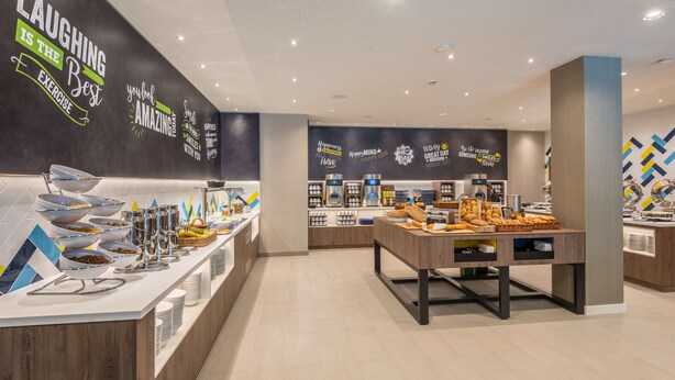 Uma zona de pequeno-almoço moderna com diversas opções de comida e arte inspiradora nas paredes.