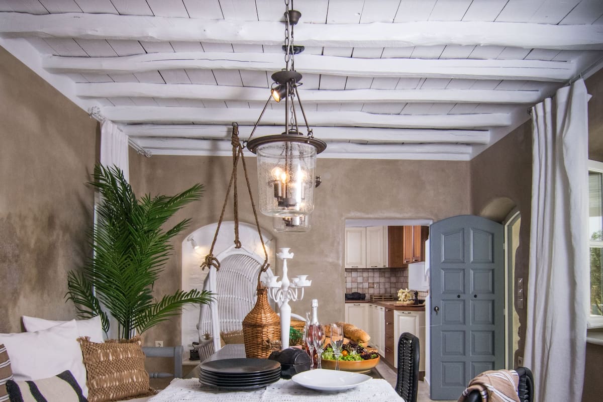 Uma sala de jantar com mesa, cadeiras e um lustre.