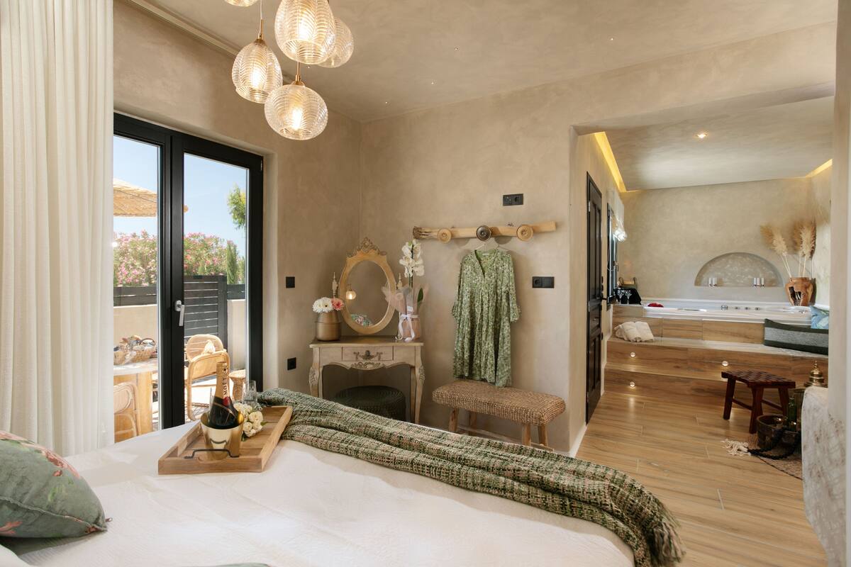 Um quarto com cama, mesa de cabeceira e vista para a varanda.