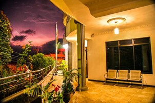 Um saguão de hotel com área de espera, escadaria e vista do céu.