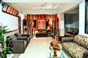 Uma sala de estar com sofás, uma mesa de centro e um altar decorativo.
