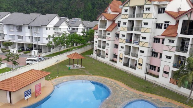 Um edifício residencial com várias varandas e área de piscina.