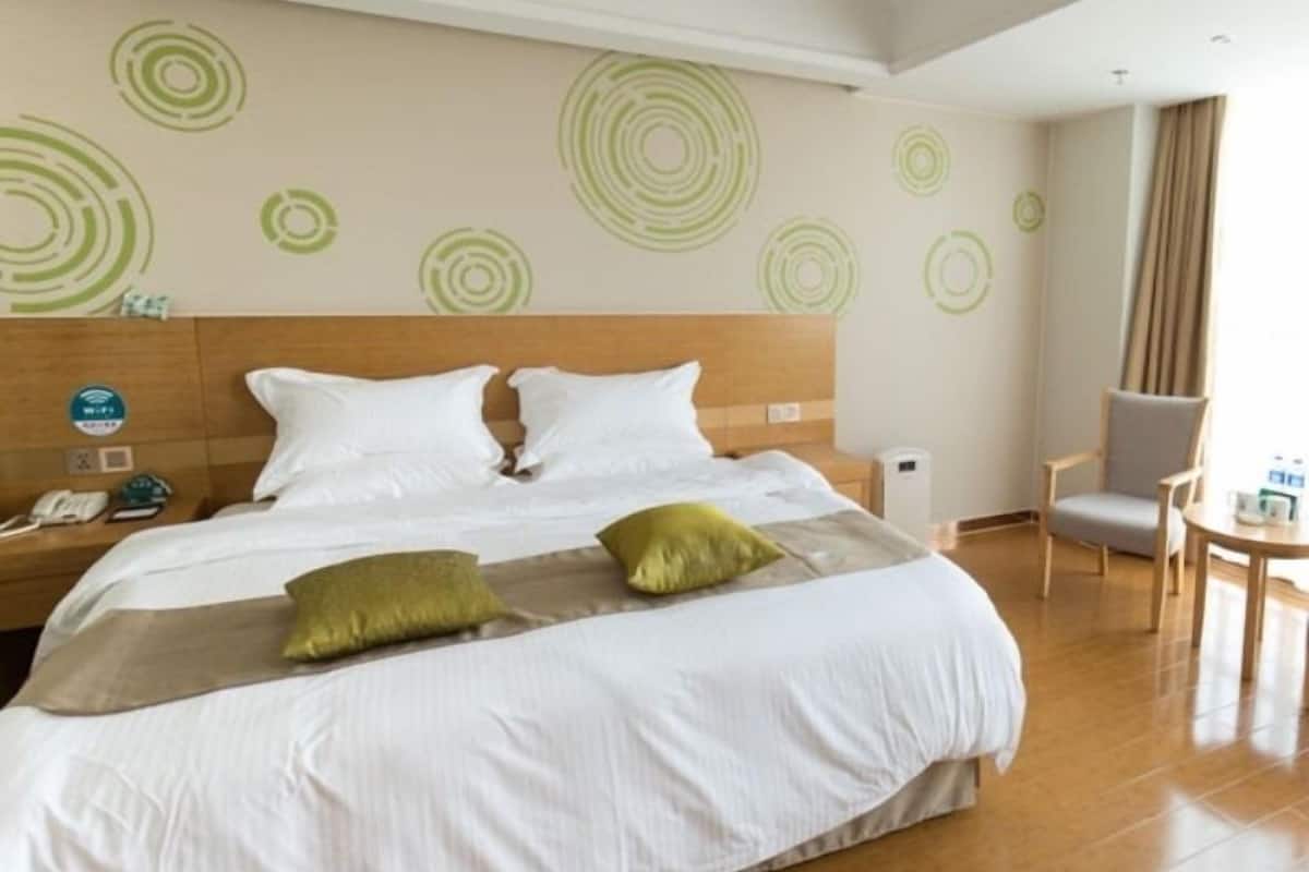 Quarto de hotel com cama, mesa de cabeceira, cadeira e mesa.
