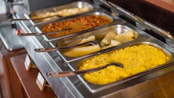 Buffet com diversos pratos, incluindo massa, arroz e legumes.