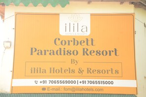 Placa do Resort Corbett Paradiso, por Ilila Hotels & Resorts, com números de contato e endereço de email.
