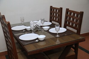 Uma mesa de jantar posta com pratos, tigelas, copos e talheres.