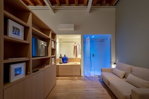 Uma sala de estar moderna com piso de madeira, um sofá bege e uma estante embutida com molduras.
