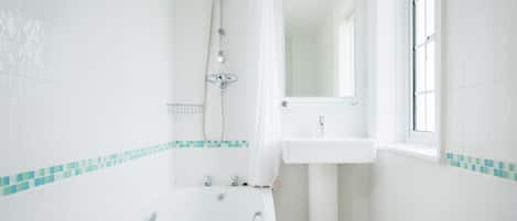 Uma casa de banho moderna com banheira, chuveiro e lavatório.