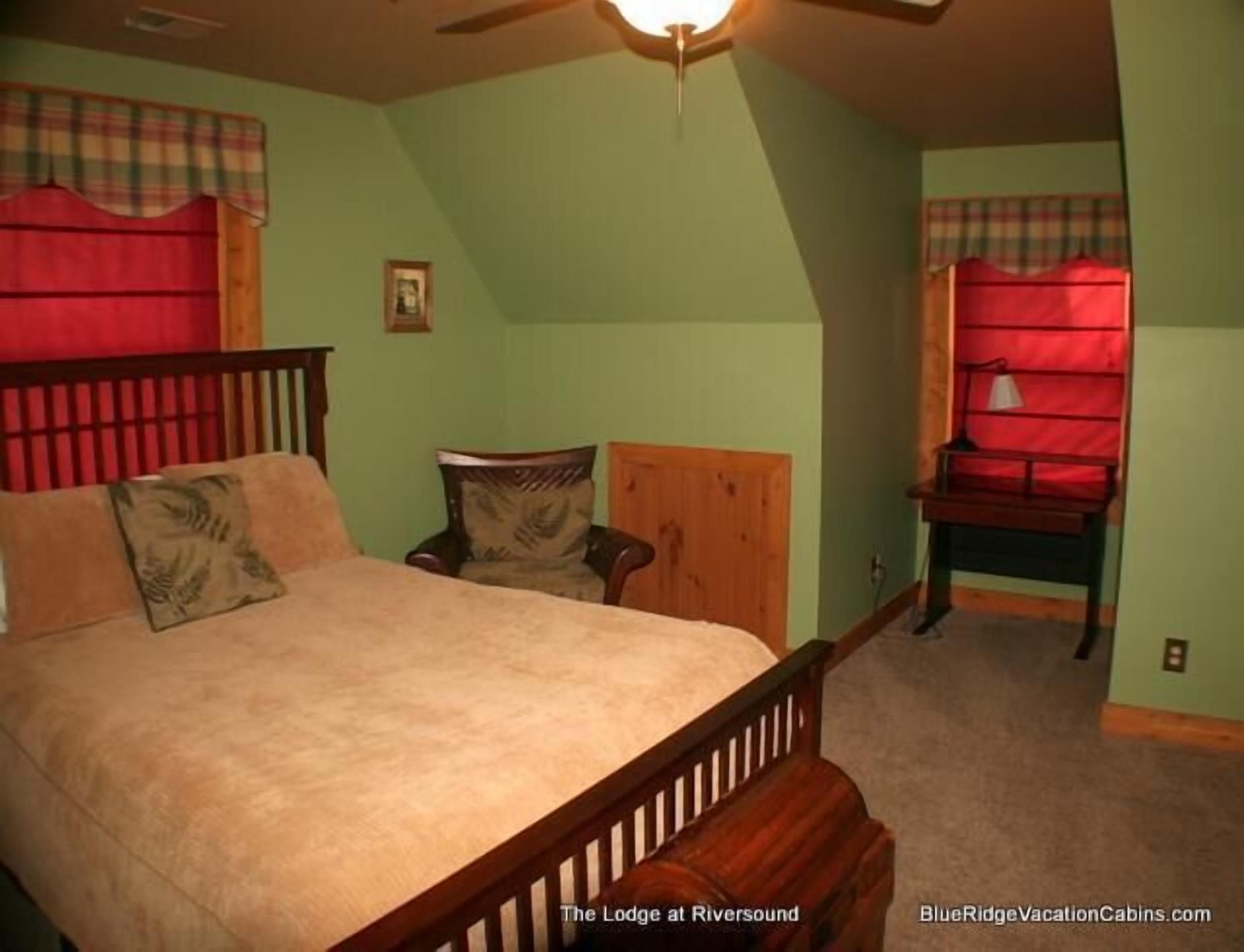 Quarto com cama de madeira, uma cadeira, uma escrivaninha e uma luminária.