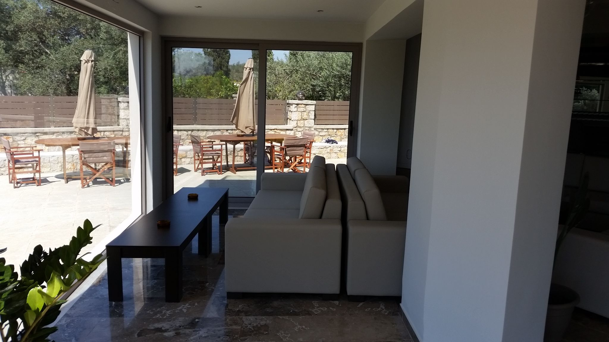 Uma sala de estar moderna com uma grande porta de vidro que dá para um espaço de pátio externo.