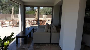 Uma sala de estar moderna com uma grande porta de vidro que dá para um espaço de pátio externo.