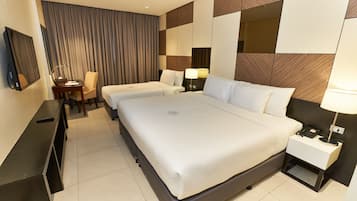 Quarto de hotel com uma cama grande, mesas de cabeceira, escrivaninha e uma cadeira.