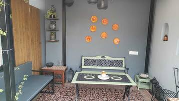 Um quarto aconchegante com um banco, uma mesa com um prato decorativo e uma parede adornada com pratos laranja redondos.