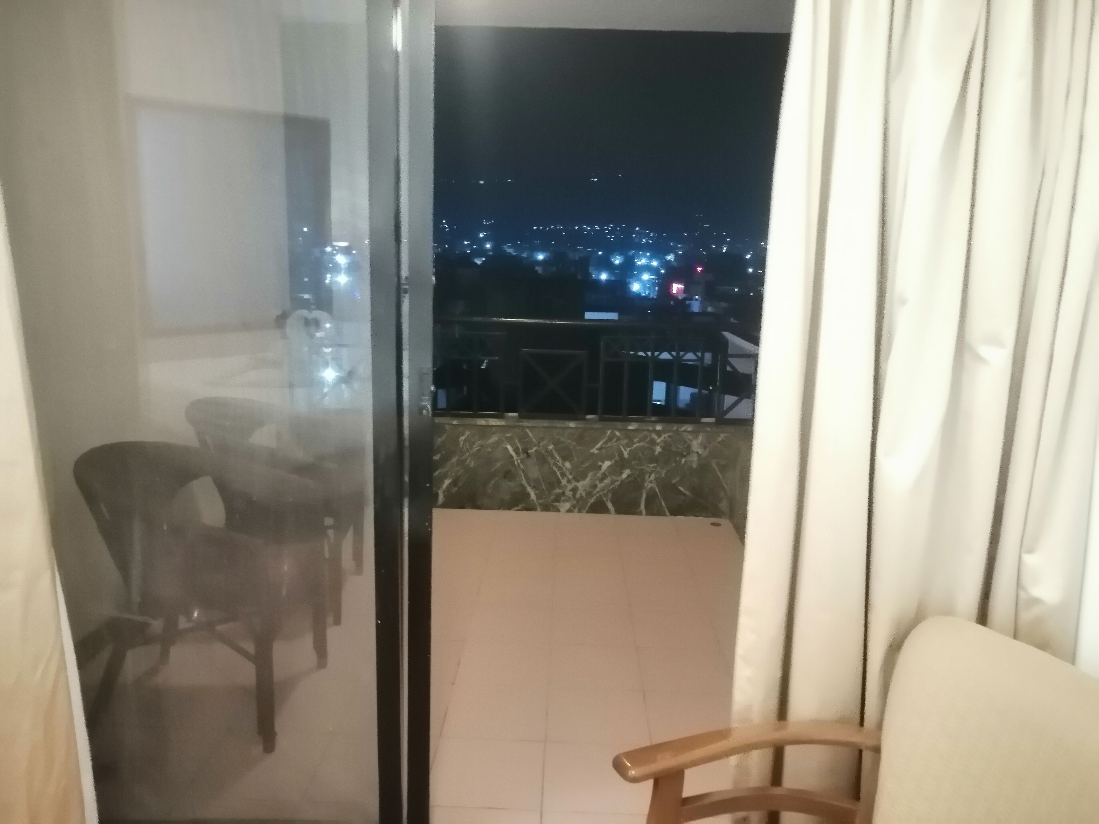 Varanda com vista noturna da cidade.