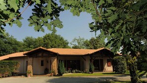Um edifício com telhado de telhas, paredes de pedra e varanda coberta.