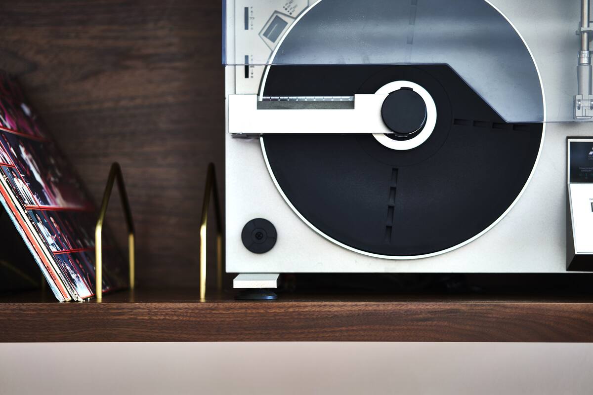 Um toca-discos com um disco de vinil sobre uma superfície de madeira.