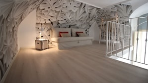 Quarto com cama grande, mesa de cabeceira e decoração na parede.