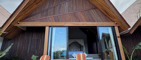 Uma villa moderna com fachada de madeira, base de pedra e entrada de vidro.