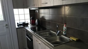Cozinha com eletrodomésticos de aço inoxidável, pia e janela.